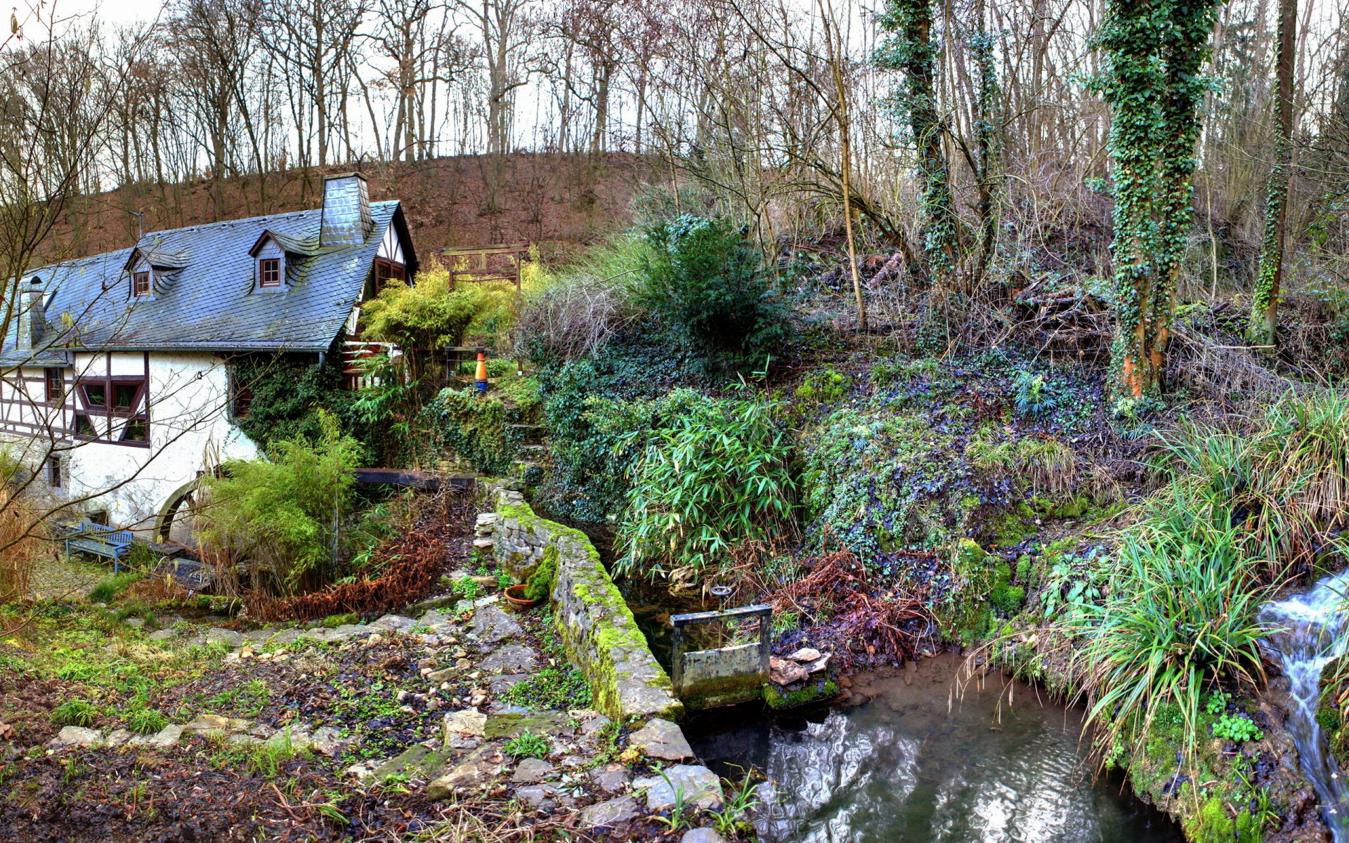 Serene Man-Made Retreat: HD Wallpaper of a Rustic House by the Stream