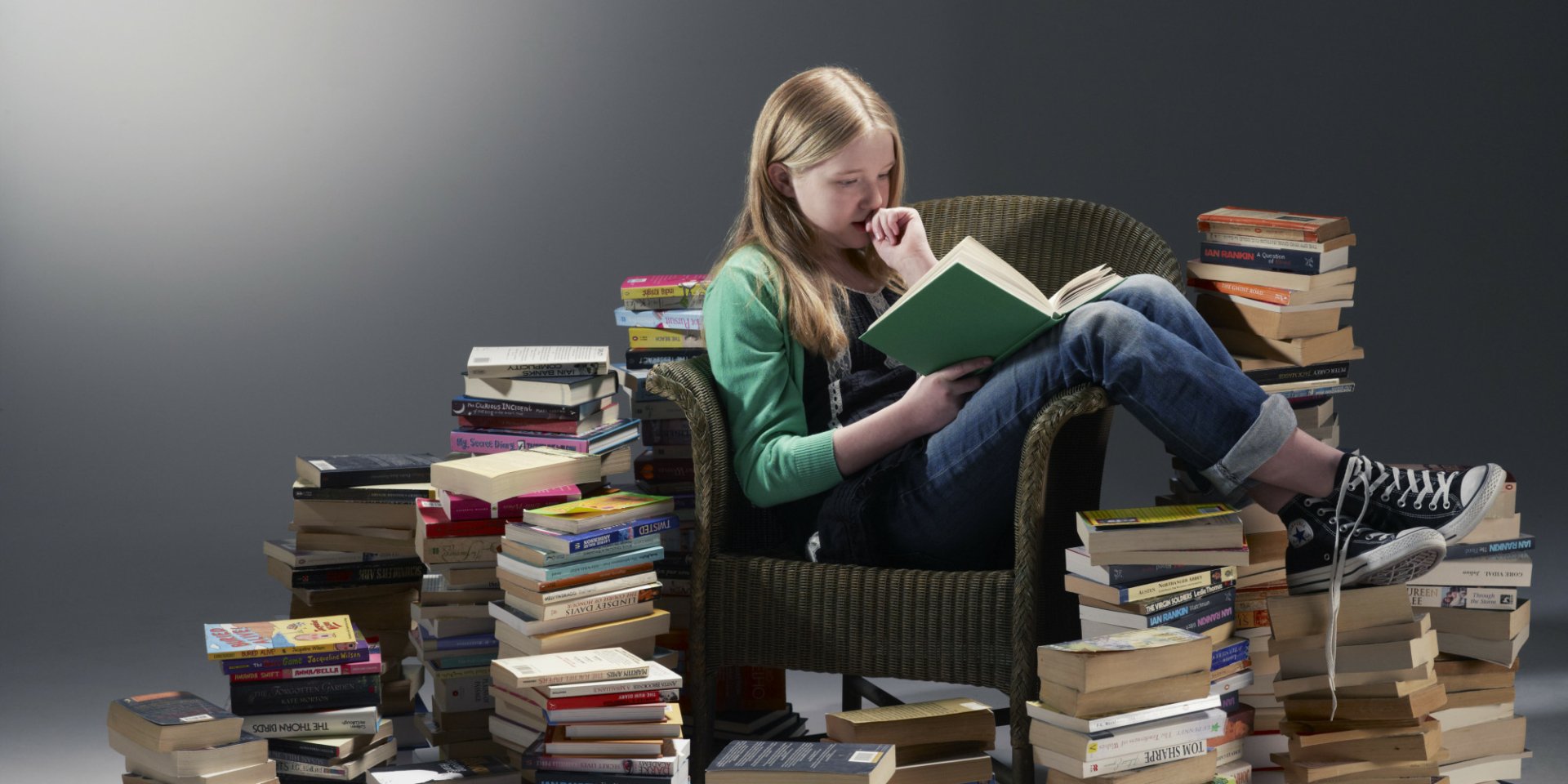 Child Engrossed in Reading Amidst Books HD Wallpaper